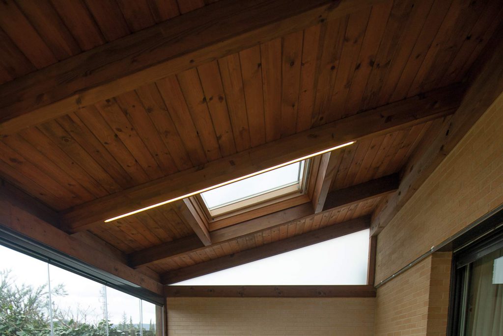 Porche acristalado con techo de madera, teja y velux | Proyectos Echarri